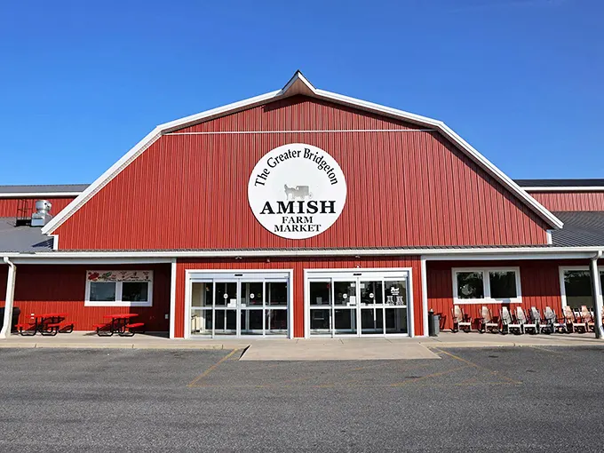 The Amish Market barn glows red with promise—inside, handcrafted treasures await at prices that won't require a second mortgage or therapy session.
