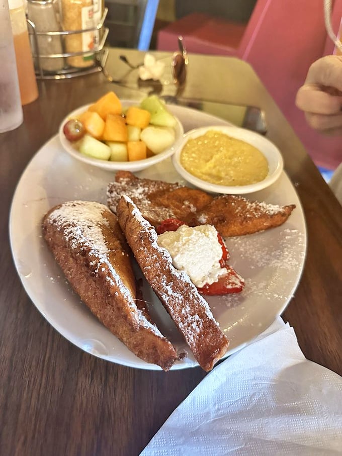 French toast that crosses into dessert territory without apology, flanked by fresh fruit that almost—almost—makes you feel virtuous about the whole affair.