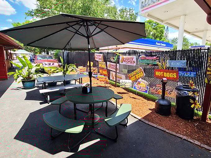 The outdoor dining area feels like a backyard cookout where everyone's invited. Those signs on the fence? They're not decoration—they're a manifesto.