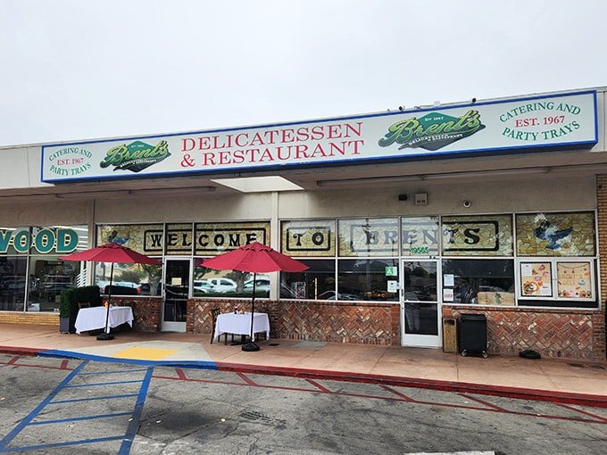 The classic storefront of Brent's Deli beckons with its nostalgic charm. Those red umbrellas aren't just for show—they're gateways to sandwich paradise.