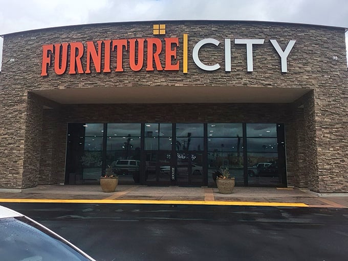 The grand entrance to Furniture City beckons with its impressive stone facade and bold signage—like the pearly gates of home decor heaven.