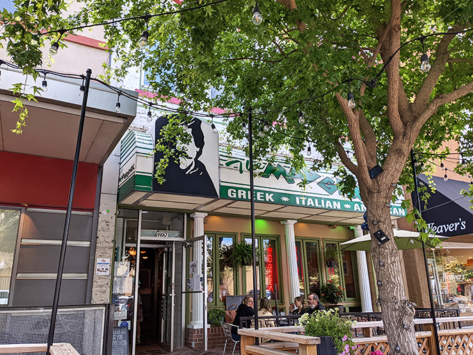 The Mad Greek's inviting storefront beckons with classic white columns and cheerful patio umbrellas—Massachusetts Street's little slice of Athens awaits your discovery.