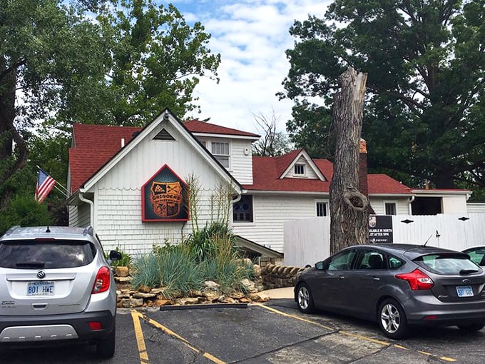 The charming cottage-like exterior of Grinders Stonewall beckons with its red-trimmed sign and helpful "ENTER OVER HERE" arrow—like your coolest friend's secret hideaway.