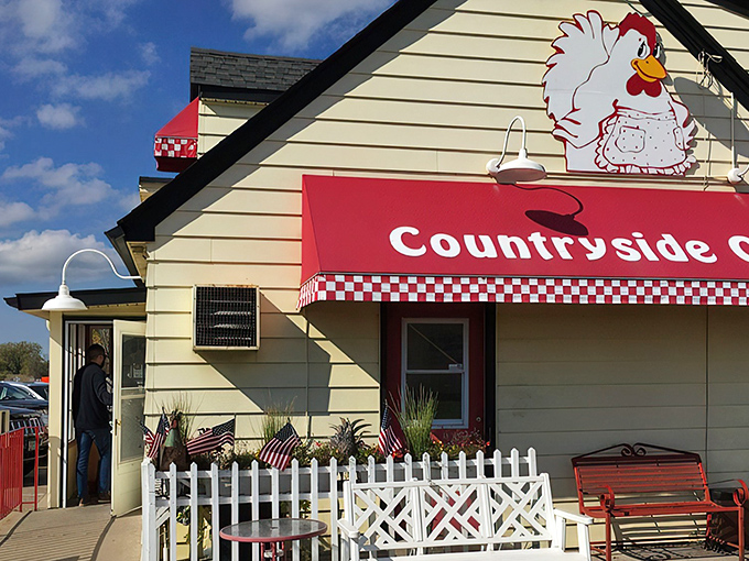 The iconic chicken mascot stands guard atop this cheerful yellow building, promising breakfast salvation to all who enter.