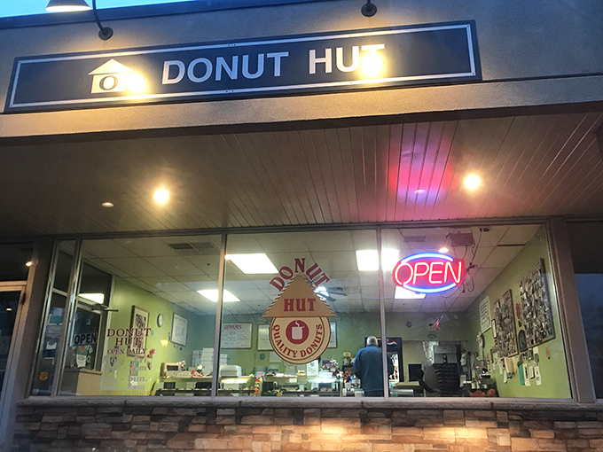 The humble storefront belies the sugary treasures within. Donut Hut's glowing "OPEN" sign serves as a beacon for pastry pilgrims across the Twin Cities.