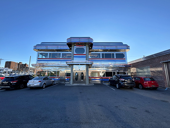 Goobers Diner gleams like a chrome-plated time machine with its red, white, and blue stripes announcing "America, served daily with a side of nostalgia."