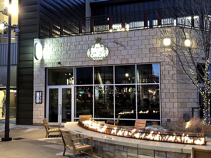 The Brass Onion's inviting exterior glows at twilight, with a cozy fire feature that practically whispers, "Come in and stay awhile."