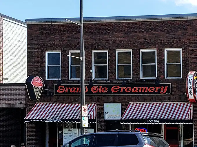 The iconic brick façade of Grand Ole Creamery, with its vintage striped awnings and neon ice cream cone sign, beckons sweet-toothed pilgrims from across Minnesota.