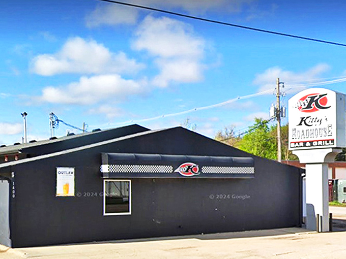 The unassuming black exterior of Kitty's Roadhouse stands like a culinary oasis in Hastings, promising roadside delights that Nebraska locals have treasured for years.