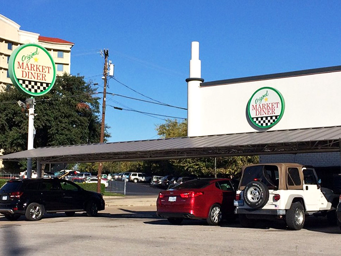 The iconic green and white signage promises comfort food salvation, standing defiantly against Dallas's modernizing skyline. 