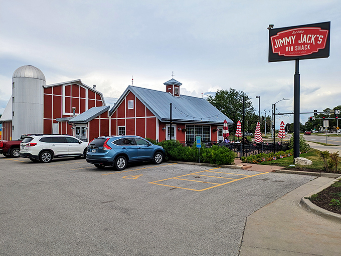 The red barn-like structure with its silo isn't just architectural flair—it's a beacon calling hungry travelers home to barbecue paradise.