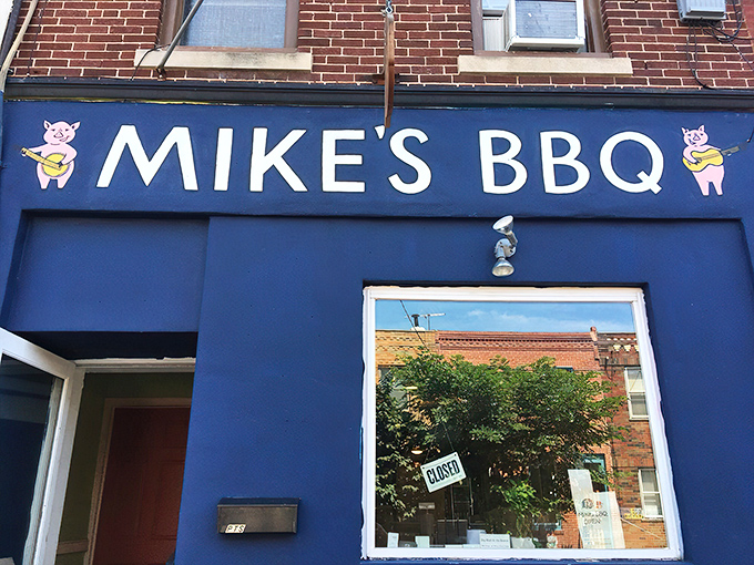 The blue storefront with cartoon pigs playing banjos isn't just cute – it's a beacon of smoky promise in South Philly's culinary landscape.