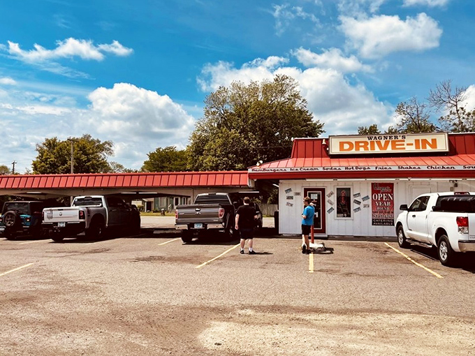 The iconic red-roofed Wagner's Drive-In stands like a time portal to simpler days, beckoning hungry travelers with promises of hand-crafted burgers and nostalgia by the plateful.