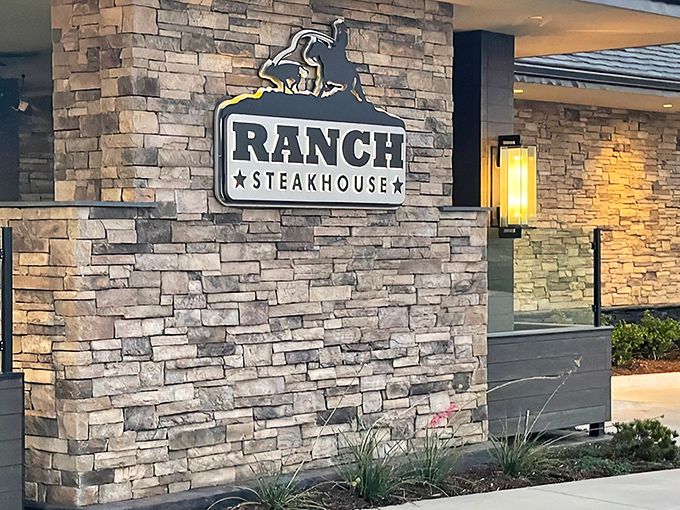 The modern stone facade of Ranch Steakhouse stands confidently against the Oklahoma sky, like a culinary fortress promising delicious treasures within.