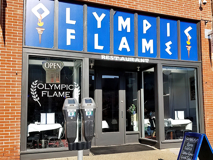 The blue signage of Olympic Flame beckons like a Mediterranean lighthouse amid Des Moines' brick buildings. Greek cuisine awaits!