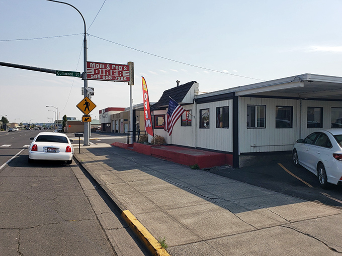The classic red and white sign beckons like a lighthouse for hungry travelers. Mom and Pop's Diner isn't just a place—it's a promise of comfort ahead.