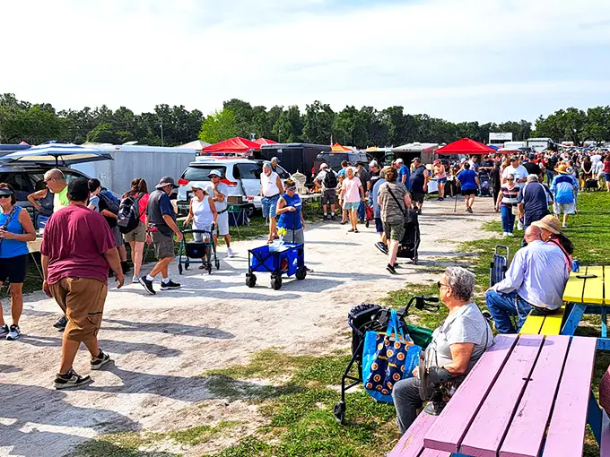 The market's main thoroughfare buzzes with activity as shoppers scan tables on both sides. Veterans know to check the corners—that's where the real treasures hide.