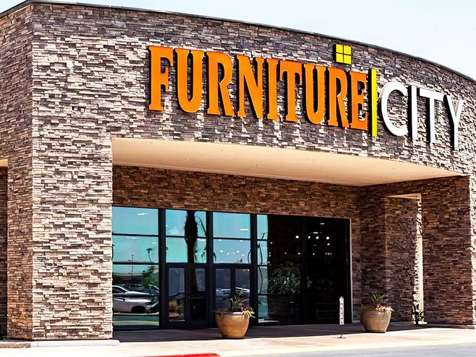 The grand entrance to Furniture City beckons with its impressive stone facade and bold signage—like the pearly gates of home decor heaven.