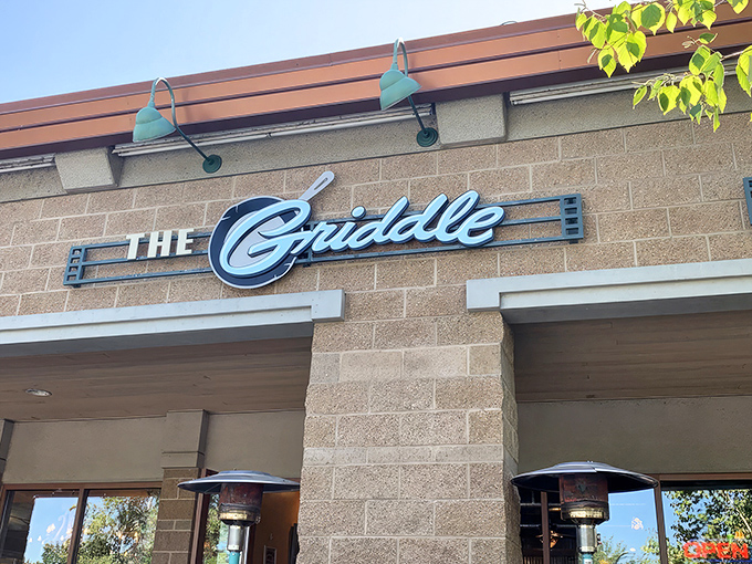 The stylish exterior of The Griddle beckons with its warm stone facade and signature blue lamps—breakfast paradise hiding in plain sight.