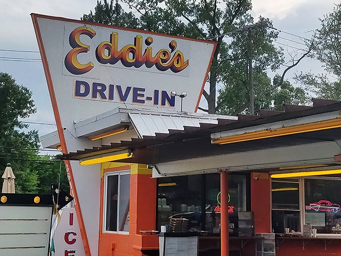 Eddie's iconic orange exterior isn't just a building—it's a time machine disguised as a drive-in, beckoning hungry travelers with its retro charm and promise of burger bliss.