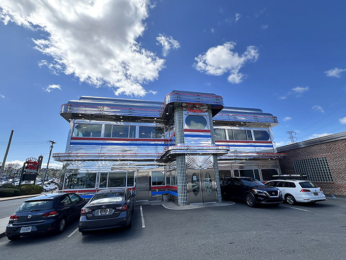 Goobers Diner gleams like a chrome-plated time machine with its red, white, and blue stripes announcing "America, served daily with a side of nostalgia."