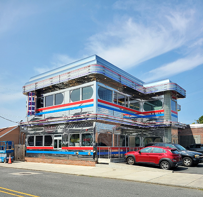 Goobers Diner gleams like a chrome-plated time machine with its red, white, and blue stripes announcing "America, served daily with a side of nostalgia."