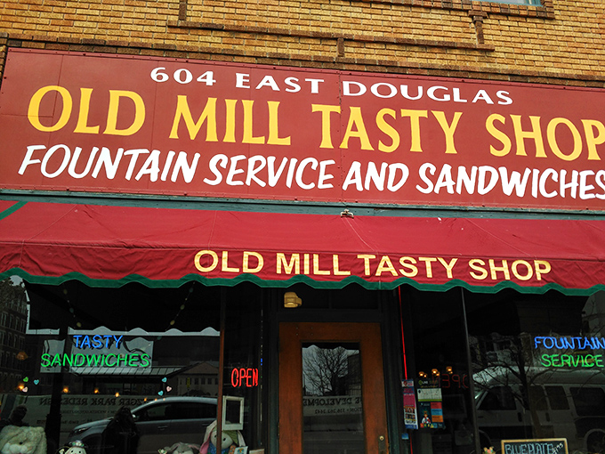 The yellow brick façade and classic red awning of Old Mill Tasty Shop isn't just a storefront—it's a time machine disguised as a downtown Wichita landmark.