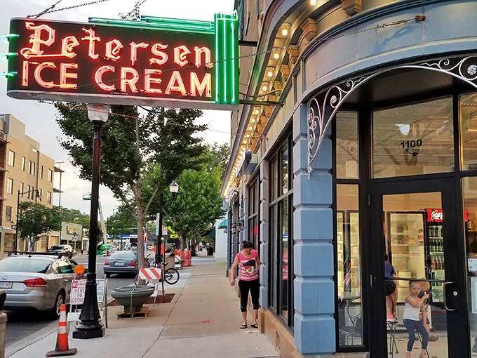 That neon sign doesn't just advertise ice cream—it's a beacon of hope on a tough day and a promise of something wonderful around that curved corner entrance.
