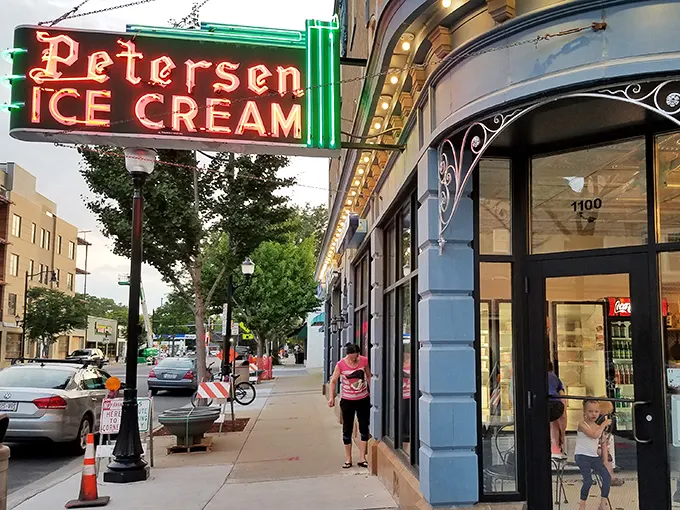 That neon sign doesn't just advertise ice cream—it's a beacon of hope on a tough day and a promise of something wonderful around that curved corner entrance.