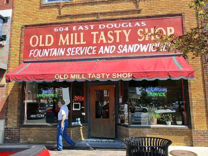 The yellow brick façade and classic red awning of Old Mill Tasty Shop isn't just a storefront—it's a time machine disguised as a downtown Wichita landmark.