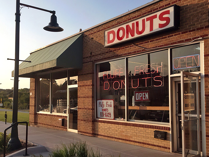 The brick facade and neon sign of Fluffy Fresh Donuts stands as a beacon of sweet promises on Johnson Drive. Mission accomplished!