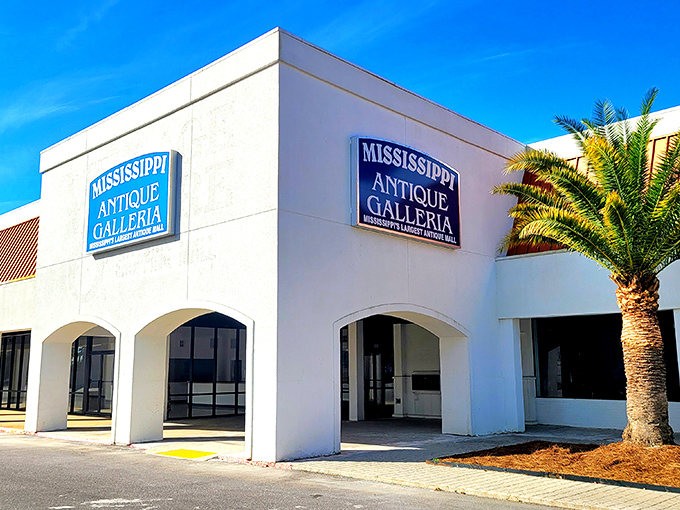 The classic car parked outside isn't just decoration—it's a time machine preview of the wonders waiting inside Mississippi Antique Galleria. 