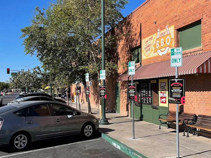 The brick fortress of flavor stands proudly on Gilbert's corner, its Arizona flag-adorned sign promising smoky treasures within. A barbecue beacon in the desert.