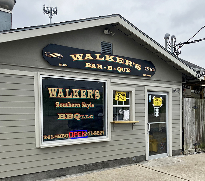 Walker's BBQ stands like a smoke-scented beacon of hope for hungry travelers. That massive smoker isn't just equipment—it's a declaration of serious barbecue intentions.