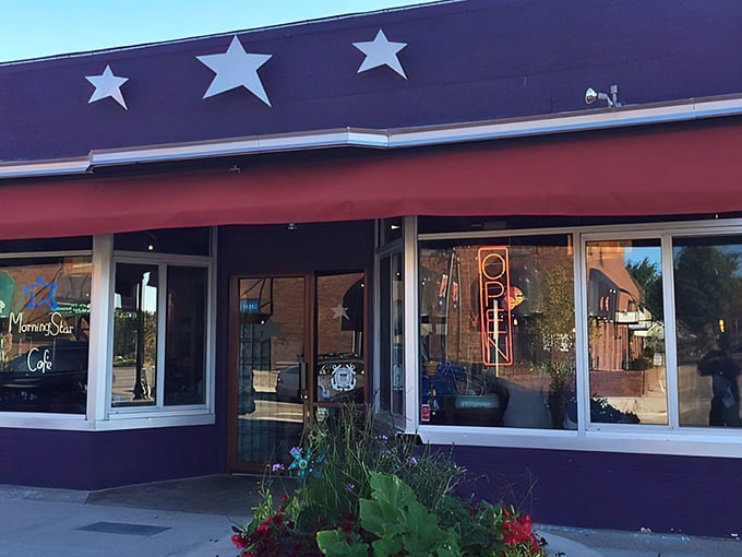 The purple facade with its cheerful red awning and hanging flower baskets isn't just eye-catching—it's nature's way of saying "breakfast is served!"