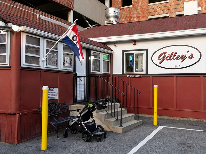 A humble red and white diner nestled against a parking garage—proof that culinary treasures often hide in plain sight.