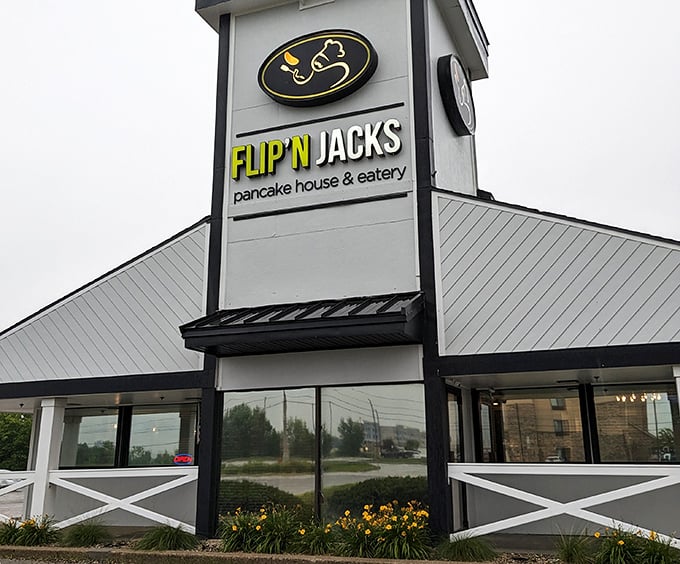 The distinctive peaked roof and farmhouse-style railing of Flip'N Jacks stands like a breakfast beacon in Ames, promising pancake paradise within.