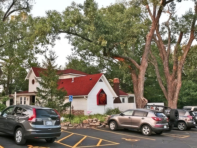 The charming cottage-like exterior of Grinders Stonewall beckons with its red-trimmed sign and helpful "ENTER OVER HERE" arrow—like your coolest friend's secret hideaway.