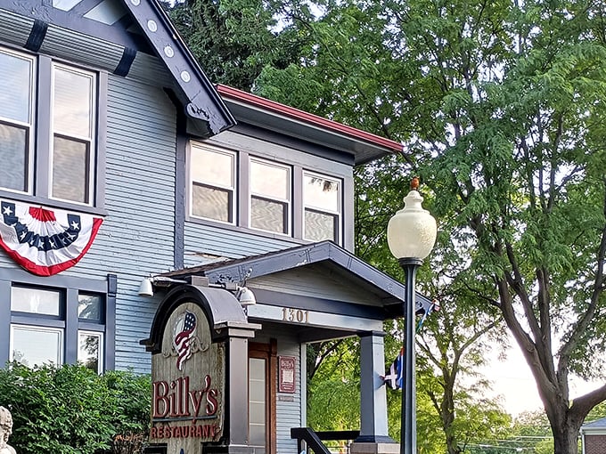 Billy's blue Victorian exterior isn't just charming—it's a culinary time machine disguised as your fancy aunt's house. The patriotic bunting adds a perfect touch.