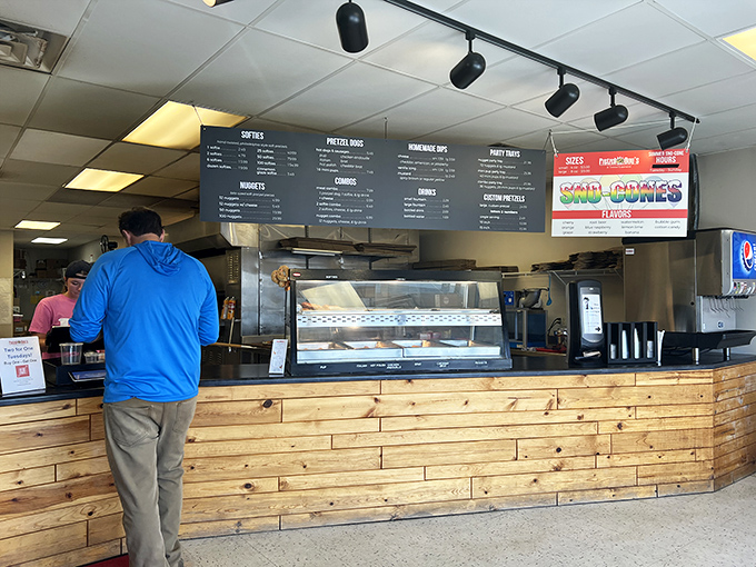 The minimalist menu board and wooden counter say, "We're serious about pretzels, not fancy décor." Priorities, perfectly aligned.