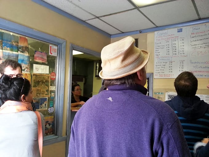 The line forms with the patience of pilgrims. That fedora isn't just a fashion statement—it's a veteran Nick's customer who knows that greatness requires a short wait.