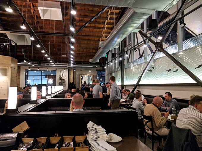 The dining room hums with the energy of people having religious experiences with seafood. That wave-inspired wall art isn't just decoration—it's foreshadowing.