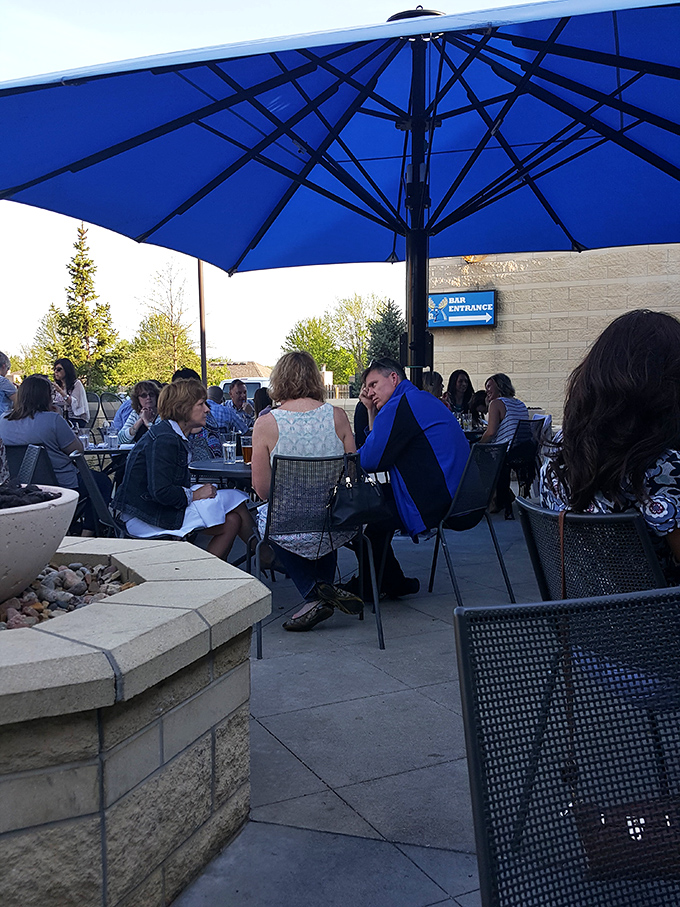 The outdoor patio—where Kansas summer evenings transform from "too hot" to "just right" under those signature blue umbrellas.