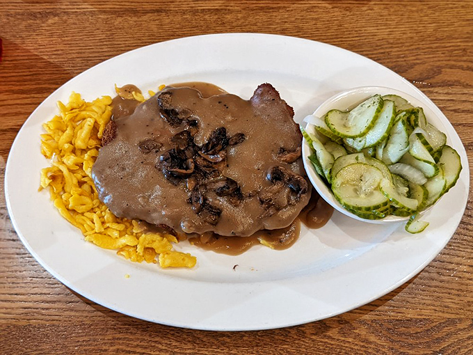 The Jägerschnitzel doesn't merely sit on the plate—it commands it, with mushroom gravy that should be bottled and sold as liquid happiness.
