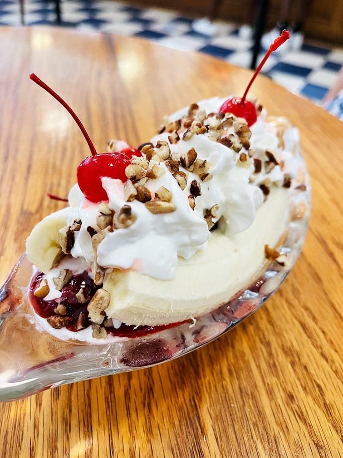 The banana split—America's dessert diplomat—bringing together fruit, ice cream, and toppings in perfect harmony on a wooden table.