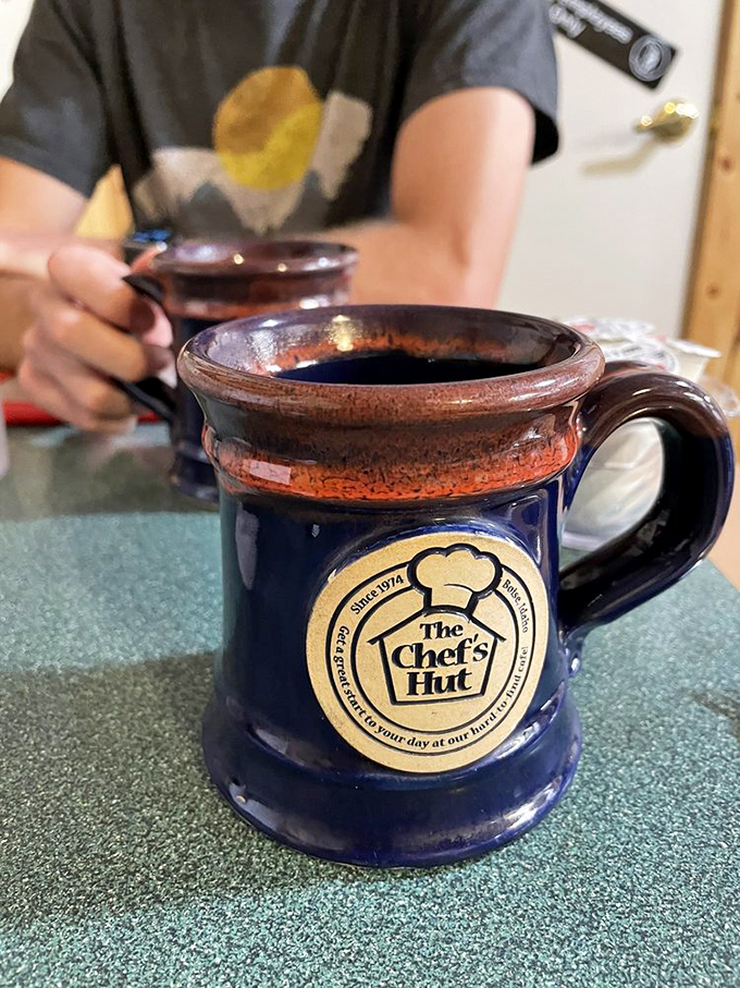 Their signature mug doesn't just hold coffee—it holds the essence of morning itself. Navy blue ceramic with the Chef's Hut logo: a silent promise of consistent comfort.