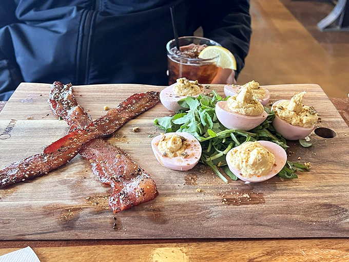 Deviled eggs and bacon strips sitting pretty on a wooden board—proof that sometimes the simplest appetizers provide the most profound happiness.
