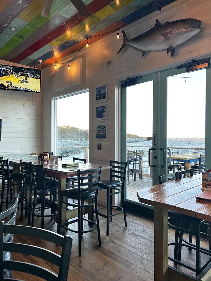 Windows framing water views and a mounted fish keeping watch—this dining room feels like the perfect blend of comfort and coastal adventure.