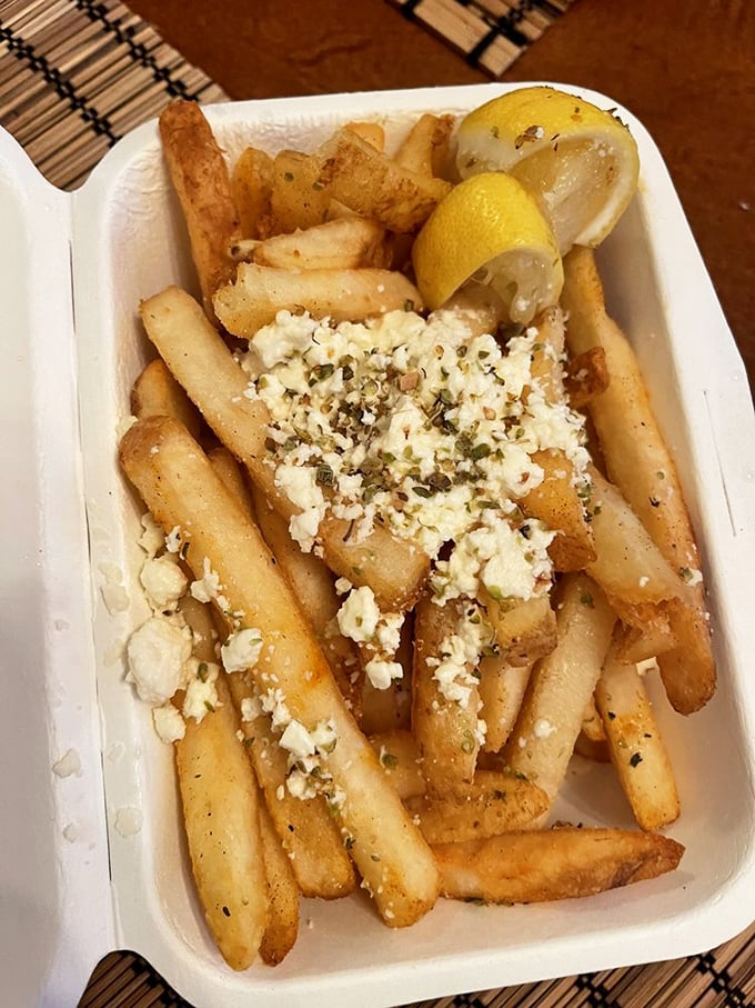 Feta-topped fries: where Michigan comfort meets Mediterranean flair. The lemon wedge isn't just for show – squeeze it and thank me later.