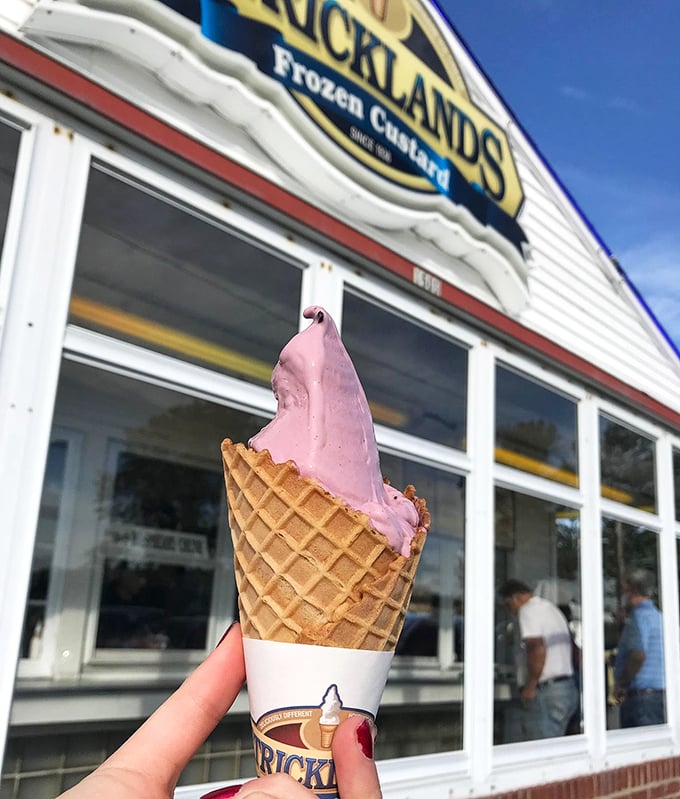 Pink perfection against the Strickland's storefront—this strawberry cone isn't just photogenic, it's the taste of summer captured in dairy form.